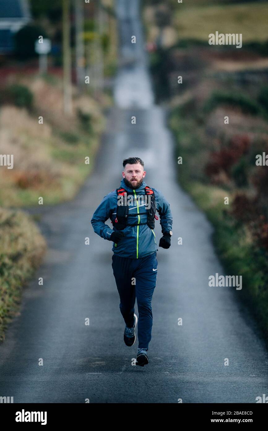 Man running on road, Glasgow, Scotland Stock Photo - Alamy