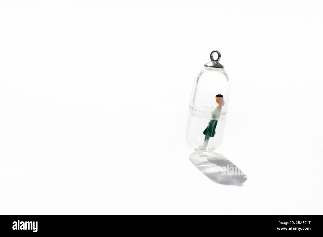 A miniature figure of a woman isolated inside a small glass capsule ...