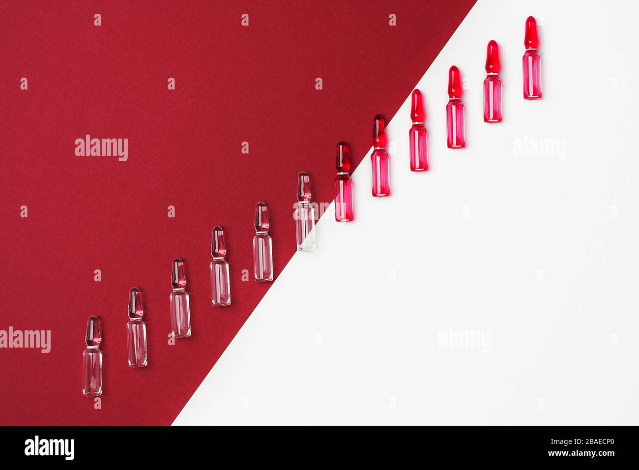 Diagonal line of ampules for injections with red and transparent liquid ...
