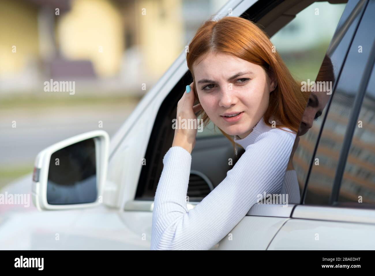 Young woman driver looking out of a car window Stock Photo - Alamy