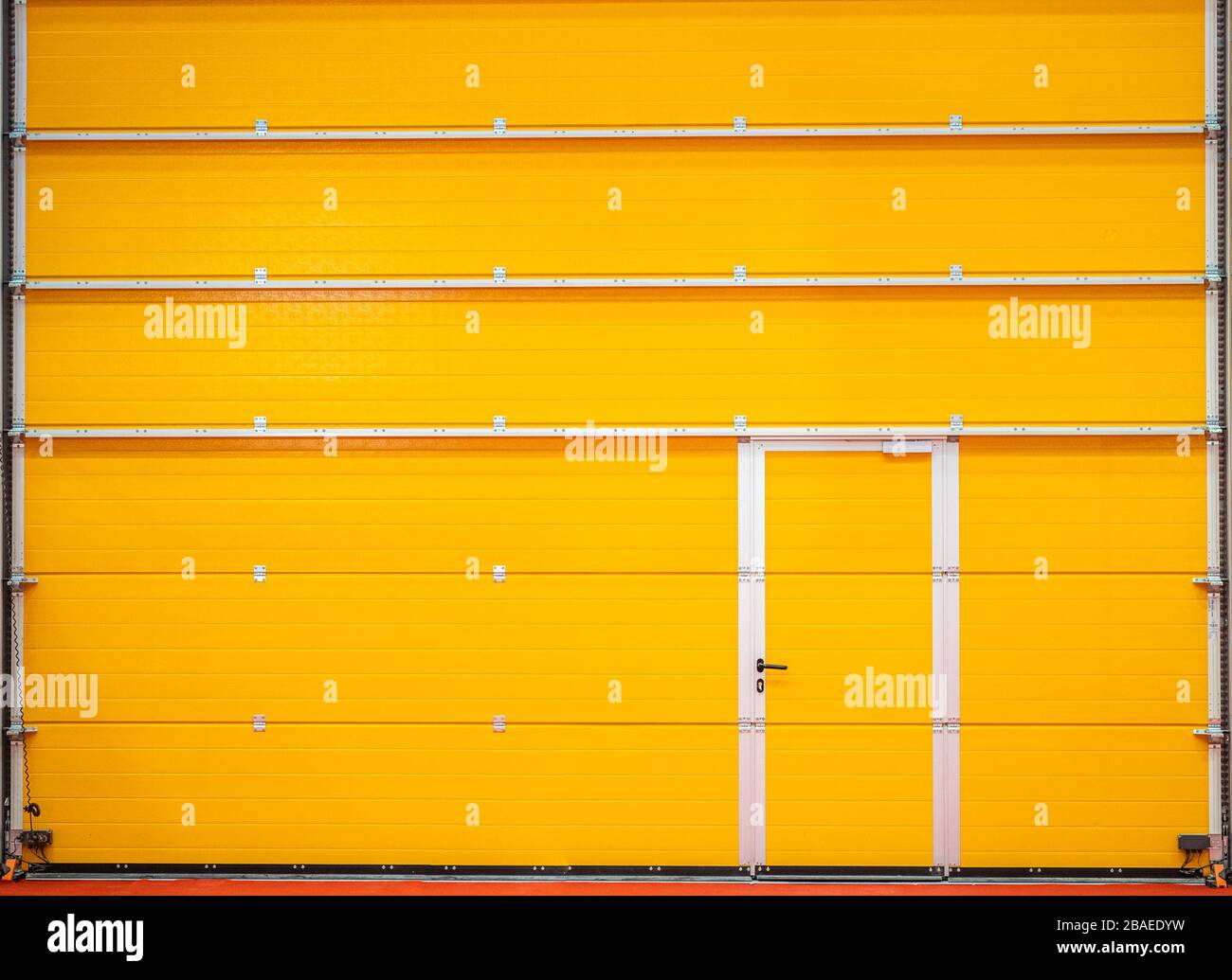 Yellow closed coiling door or roll-up of a hangar. Yellow steel ...