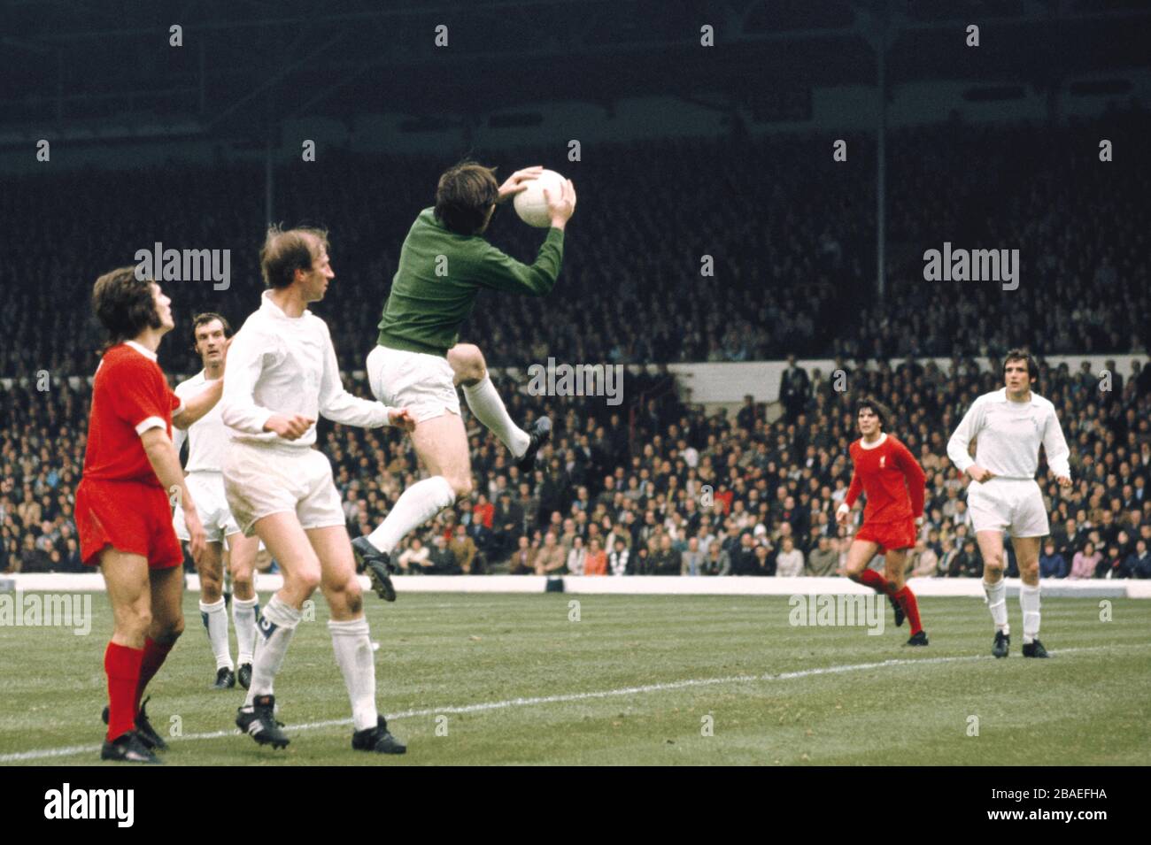 Leeds United goalkeeper David Harvey (centre) leaps to claim the ball ...