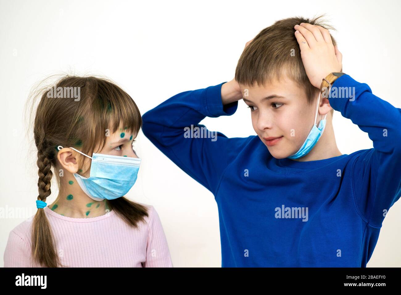 Boy and girl wearing blue protective medical mask ill with chickenpox ...