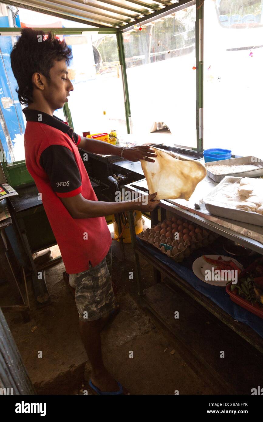 Young man preparing a roti at Chooti in Sigiriya, Sri Lanka Stock Photo ...