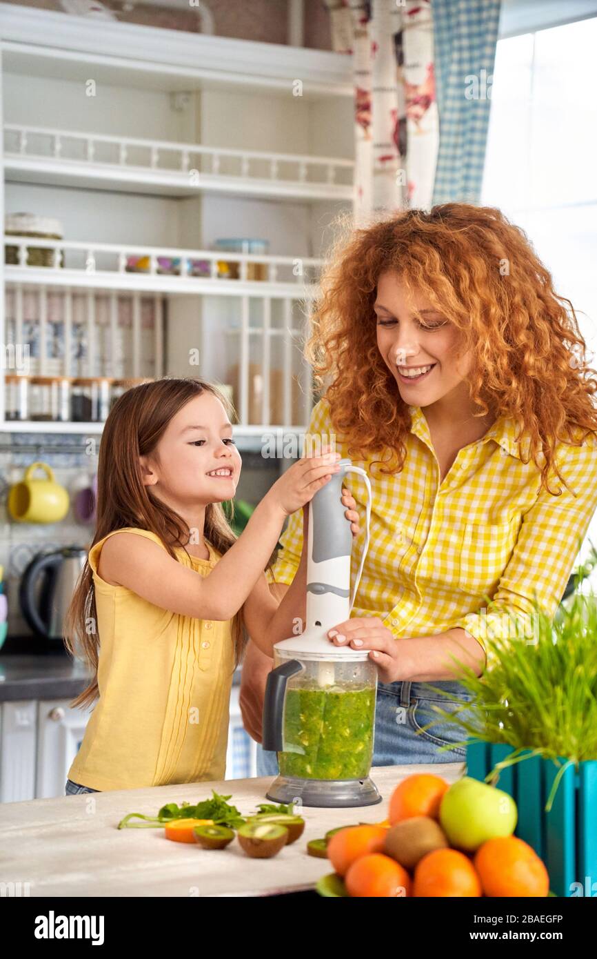 Young adult mother and her kid girl using blender in kitchen Stock ...