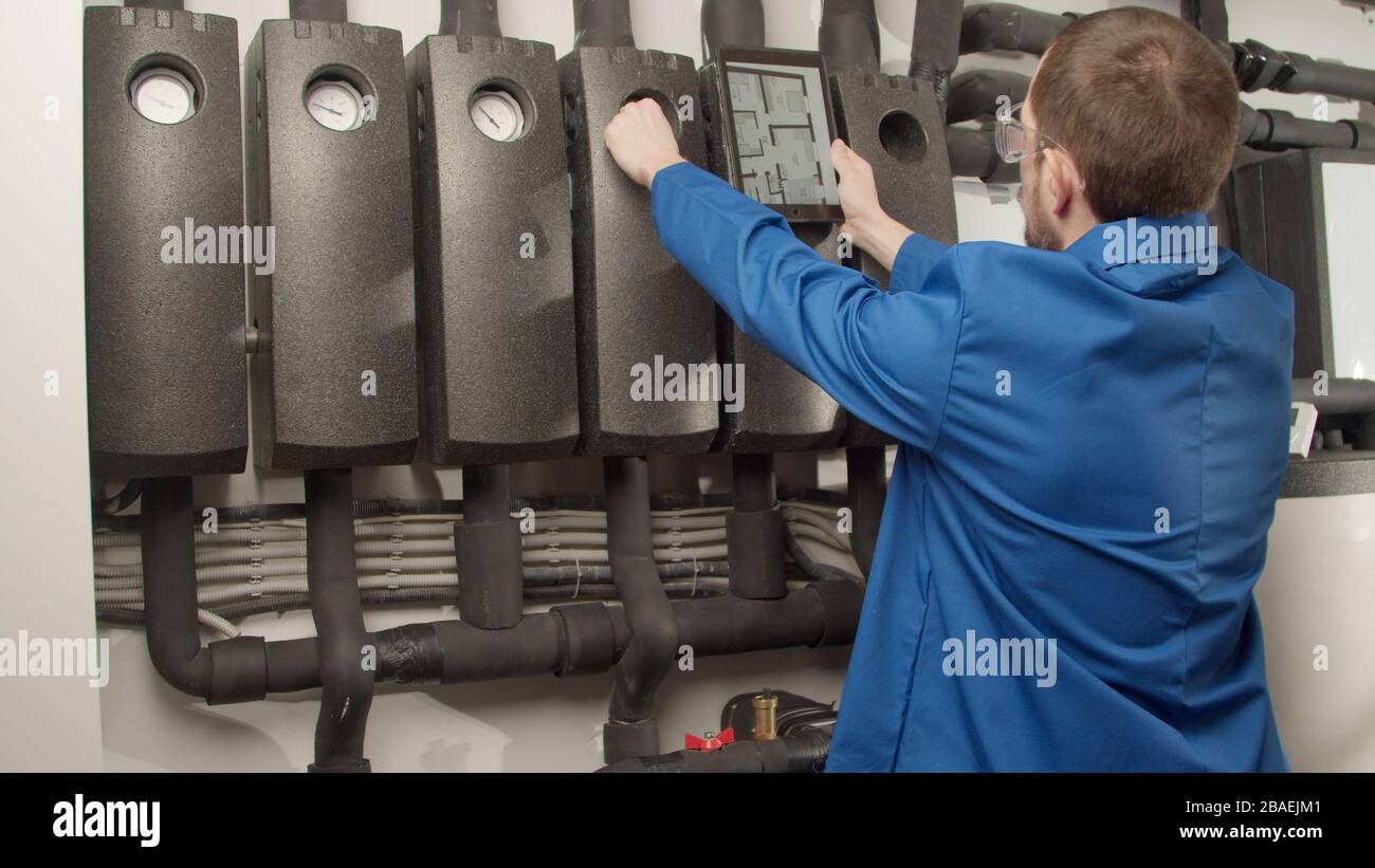 Young engineer checking new equipment with controller Stock Photo - Alamy