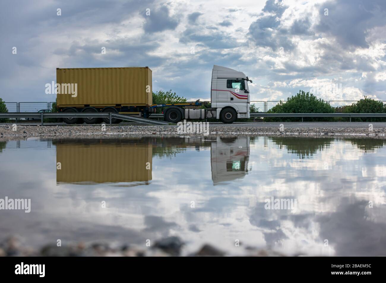 Truck transporting a container and driving on the highway Stock Photo ...