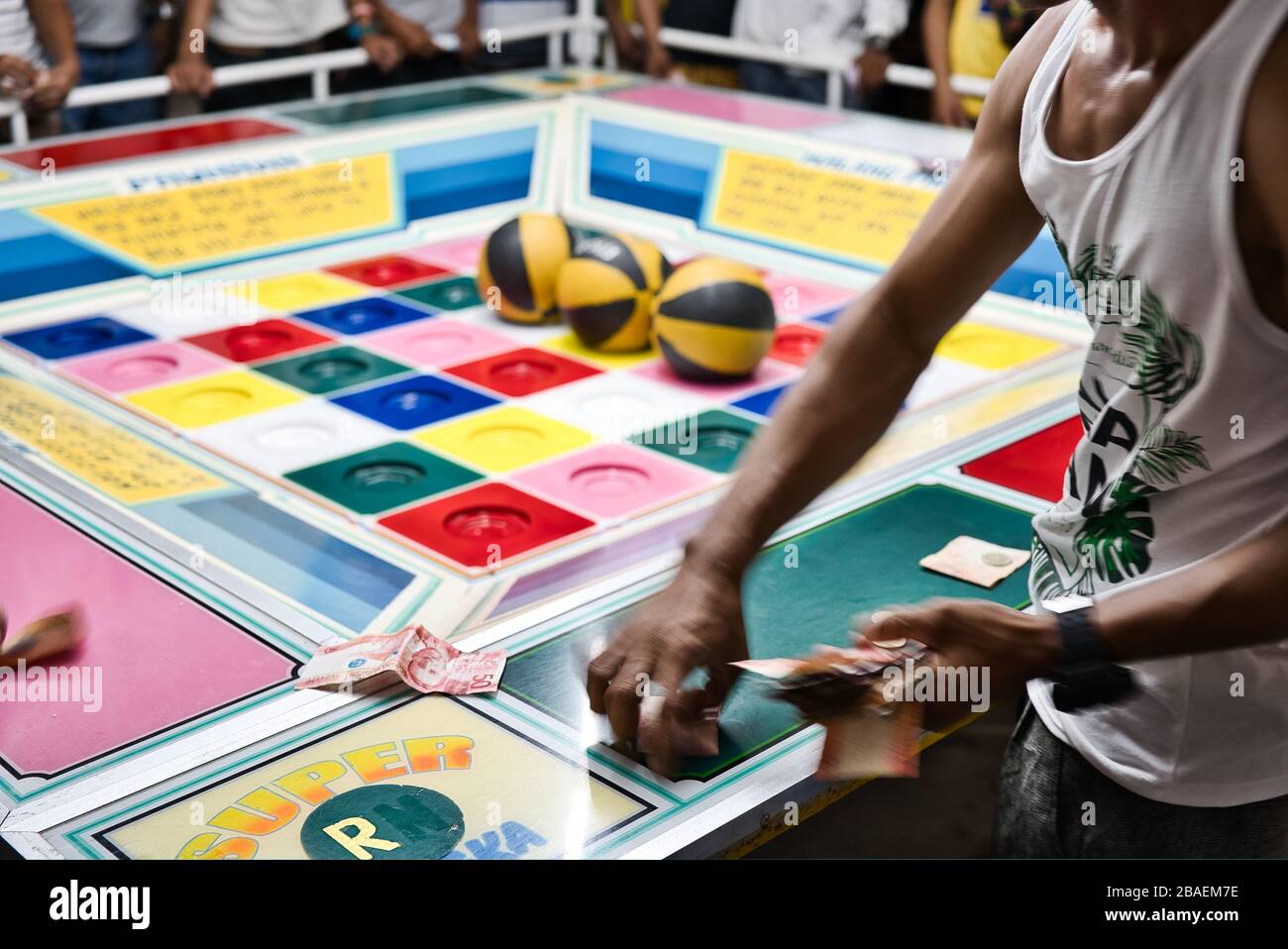 Various handspeople betting on a game of chance in the Philippines with ...