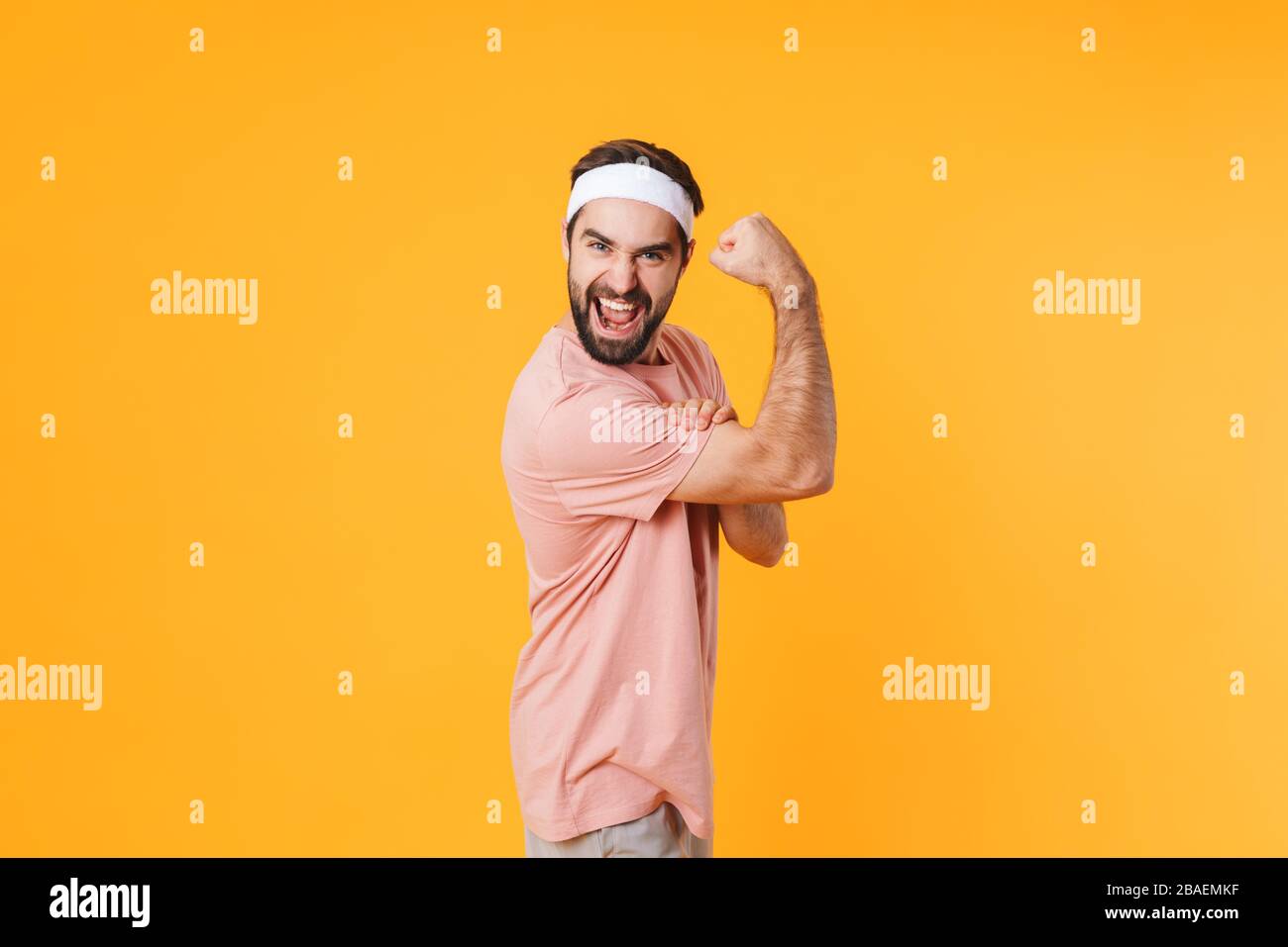 Image of muscular athletic young man in t-shirt having fun and showing ...