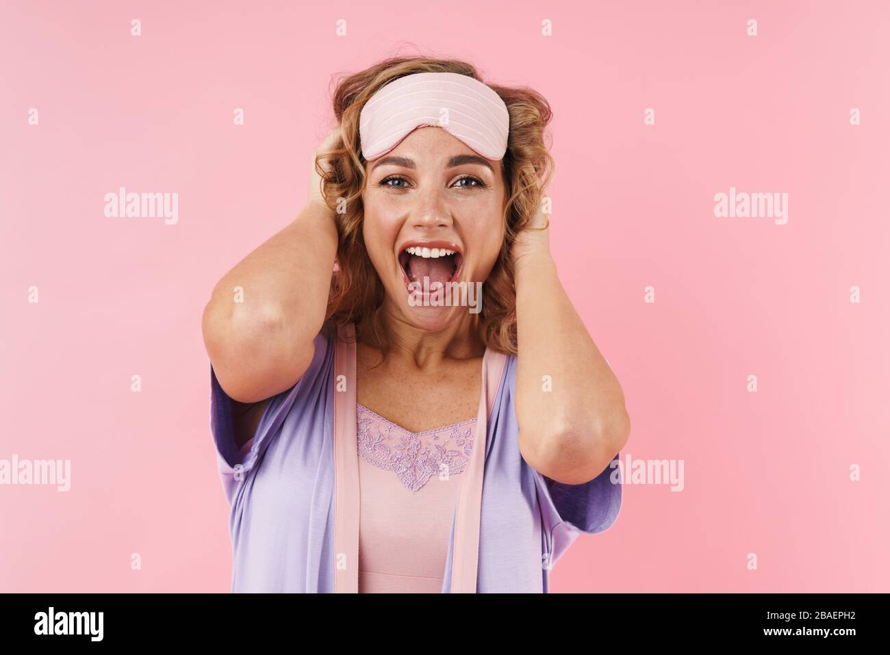 Image of young delighted woman in sleep mask screaming and grabbing her ...