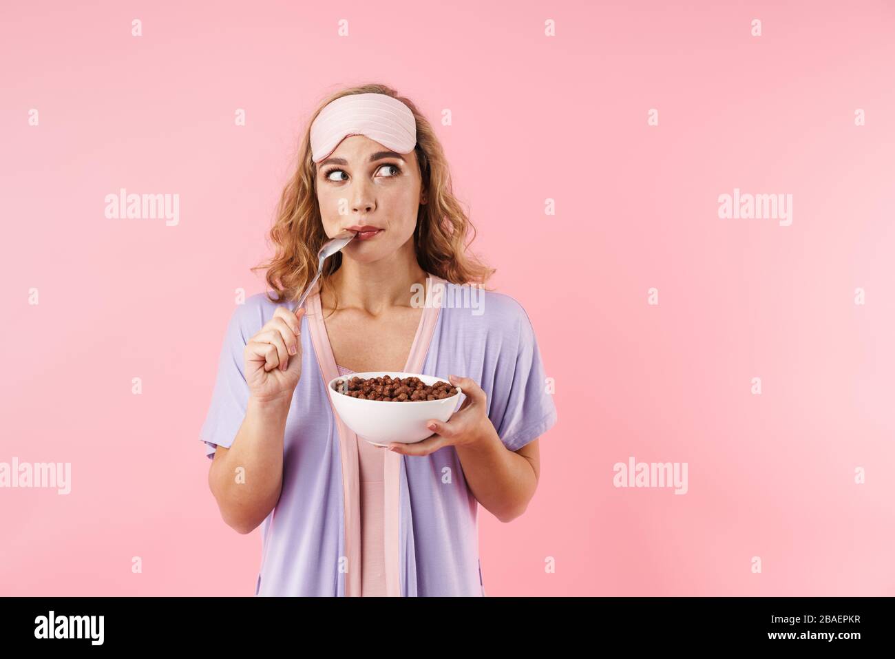 Image of caucasian thinking woman in sleep mask eating instant ...
