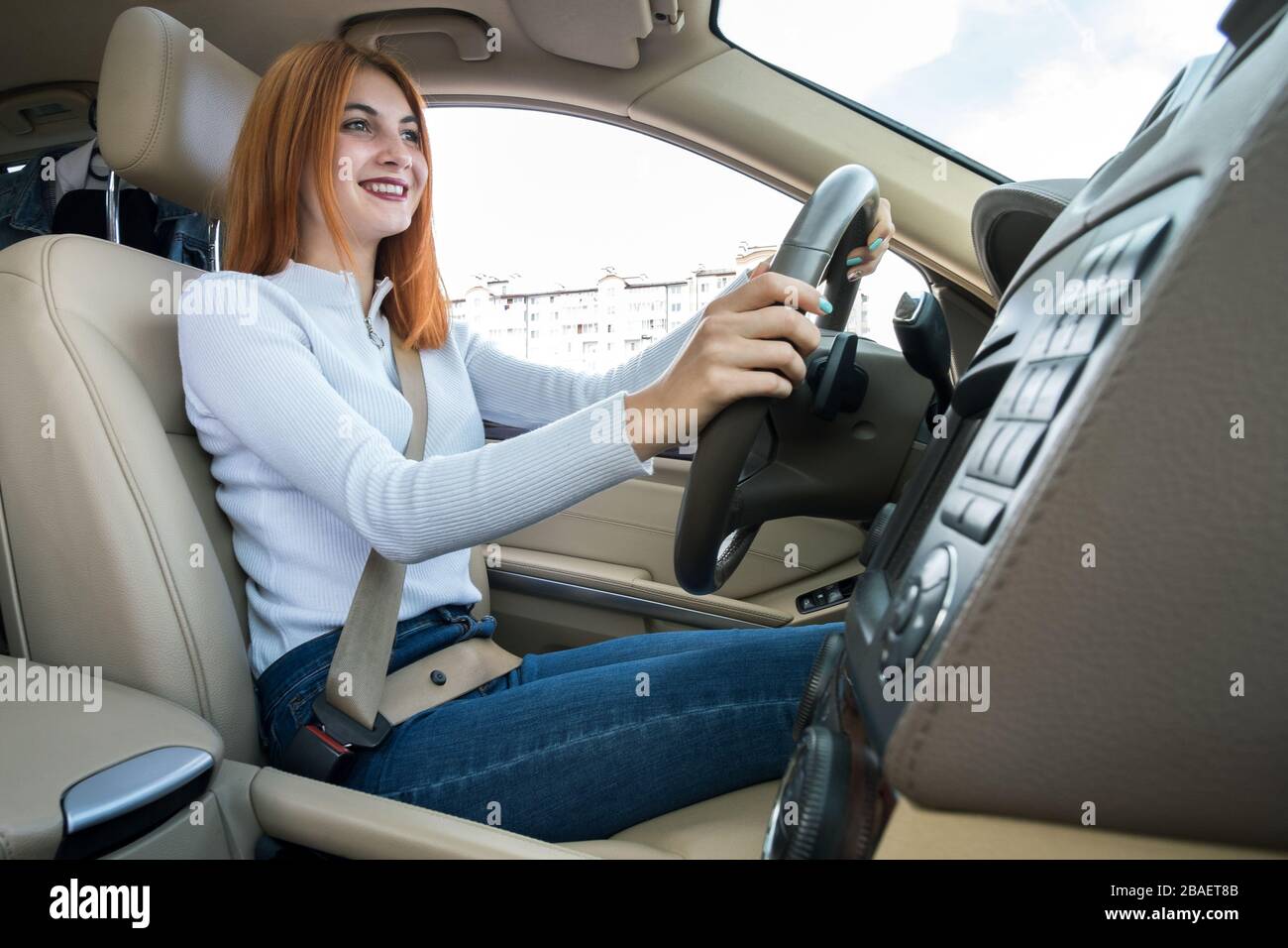 Young redhead woman driver driving a car smiling happily Stock Photo ...