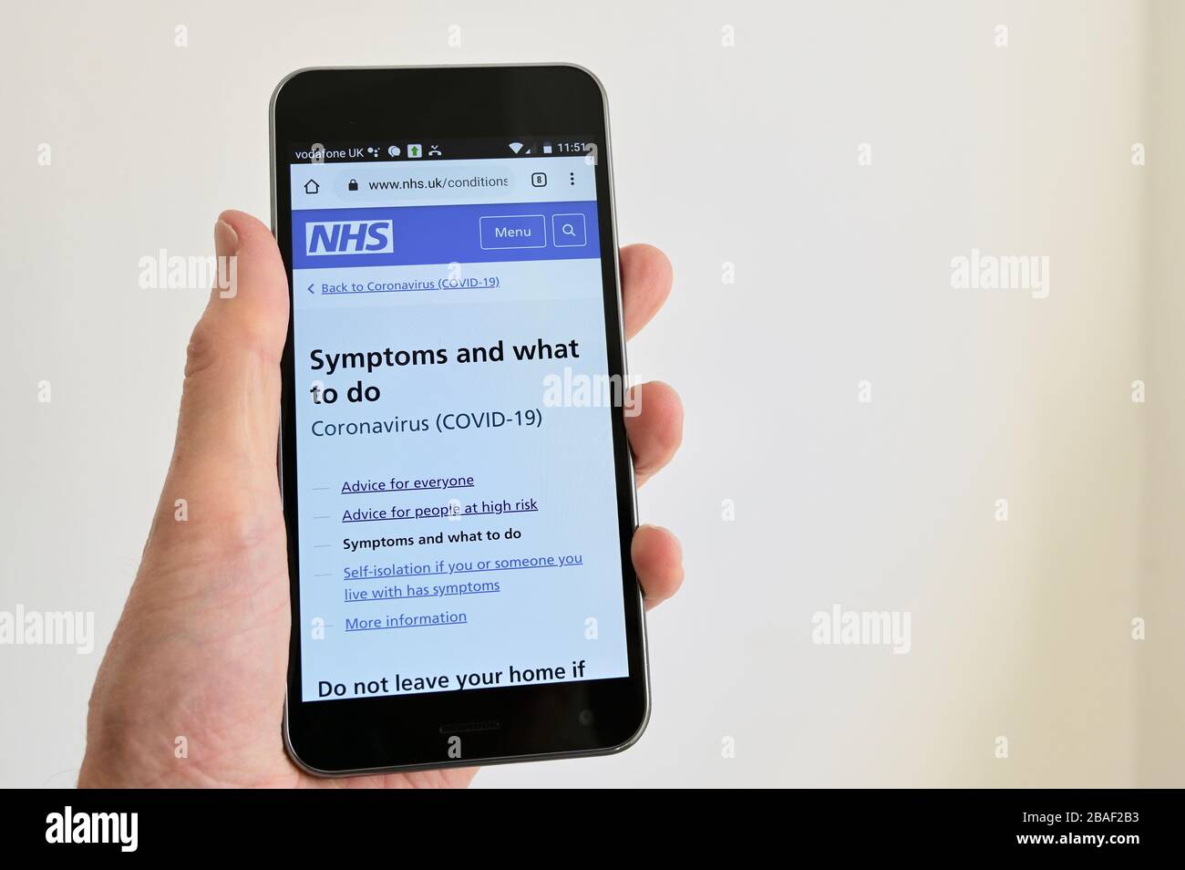 Mobile phone displaying NHS advice on Coronavirus symptoms Stock Photo ...