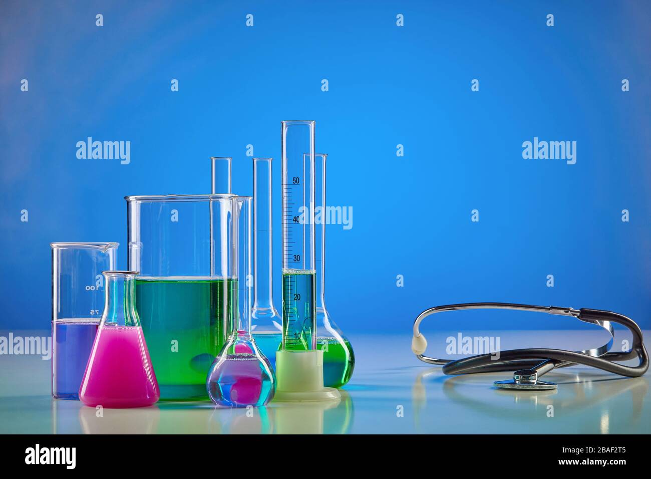 Colorful chemical reagents in beakers, medical flasks, measuring ...