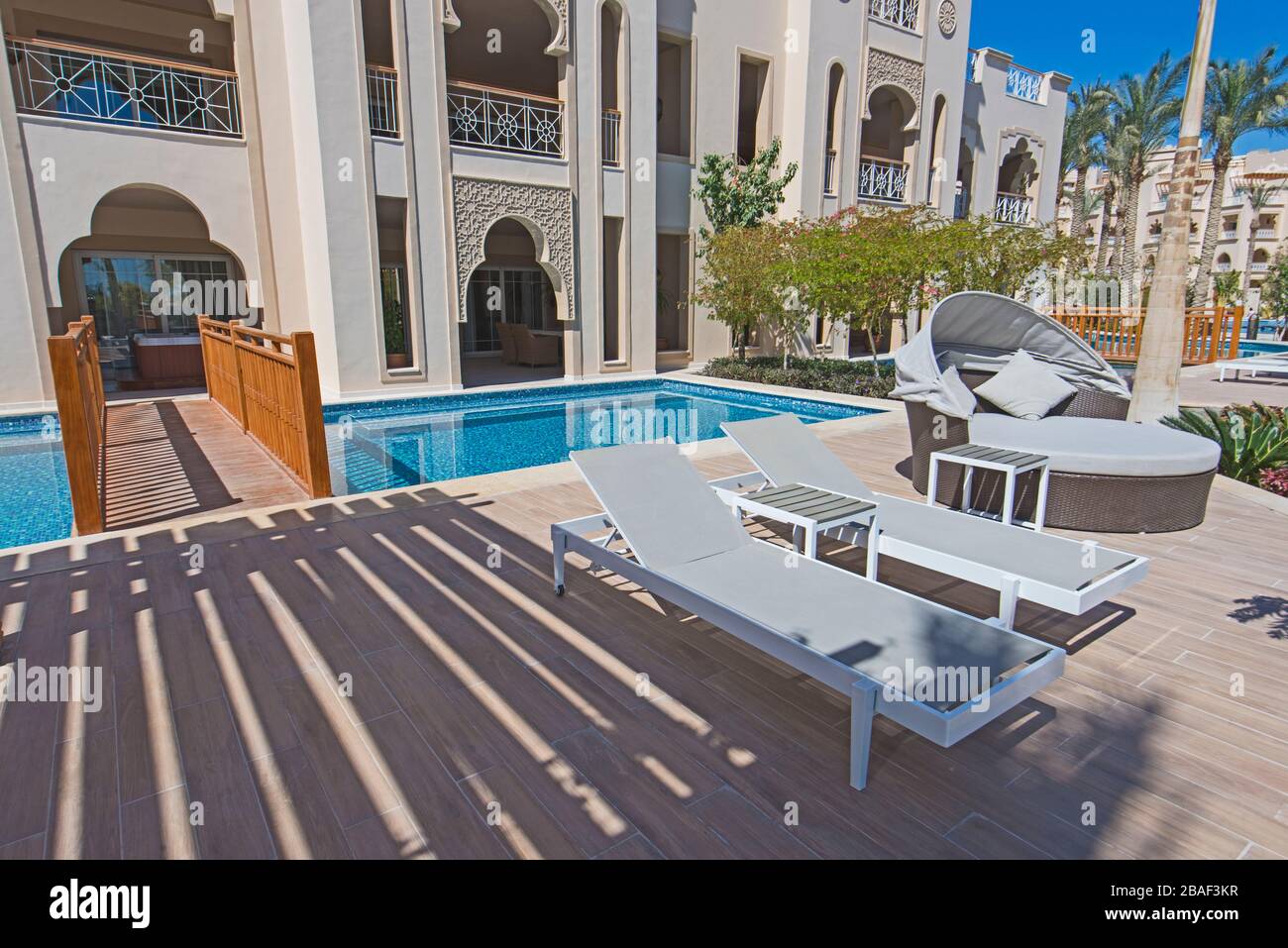Sun loungers at luxury tropical hotel resort room terrace by swimming ...