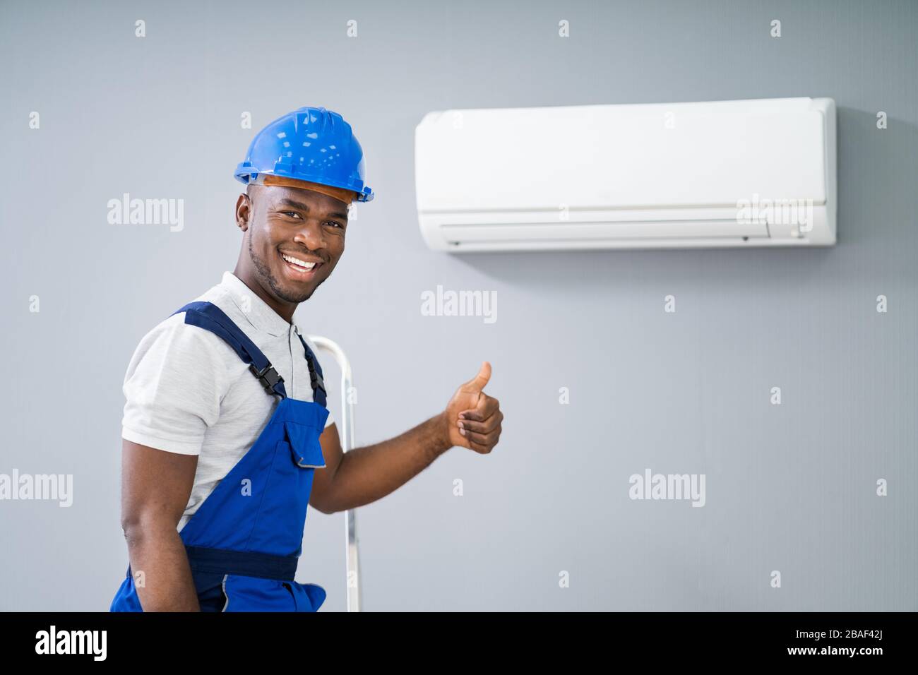 Smiling Male Electrician Gesturing Thumbs Up Near Air Conditioner Stock ...