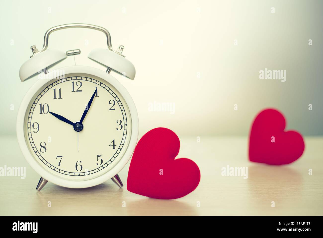 love times clock with red heart space for text Stock Photo - Alamy