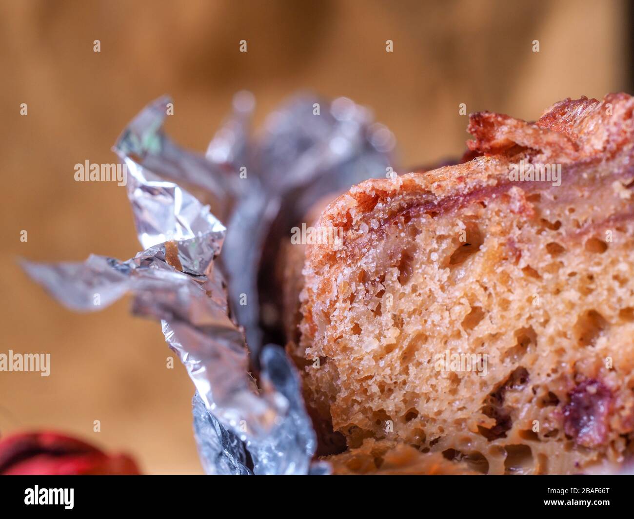 A photo of an whole flour apple pie in allu foil, on a dark rustic ...