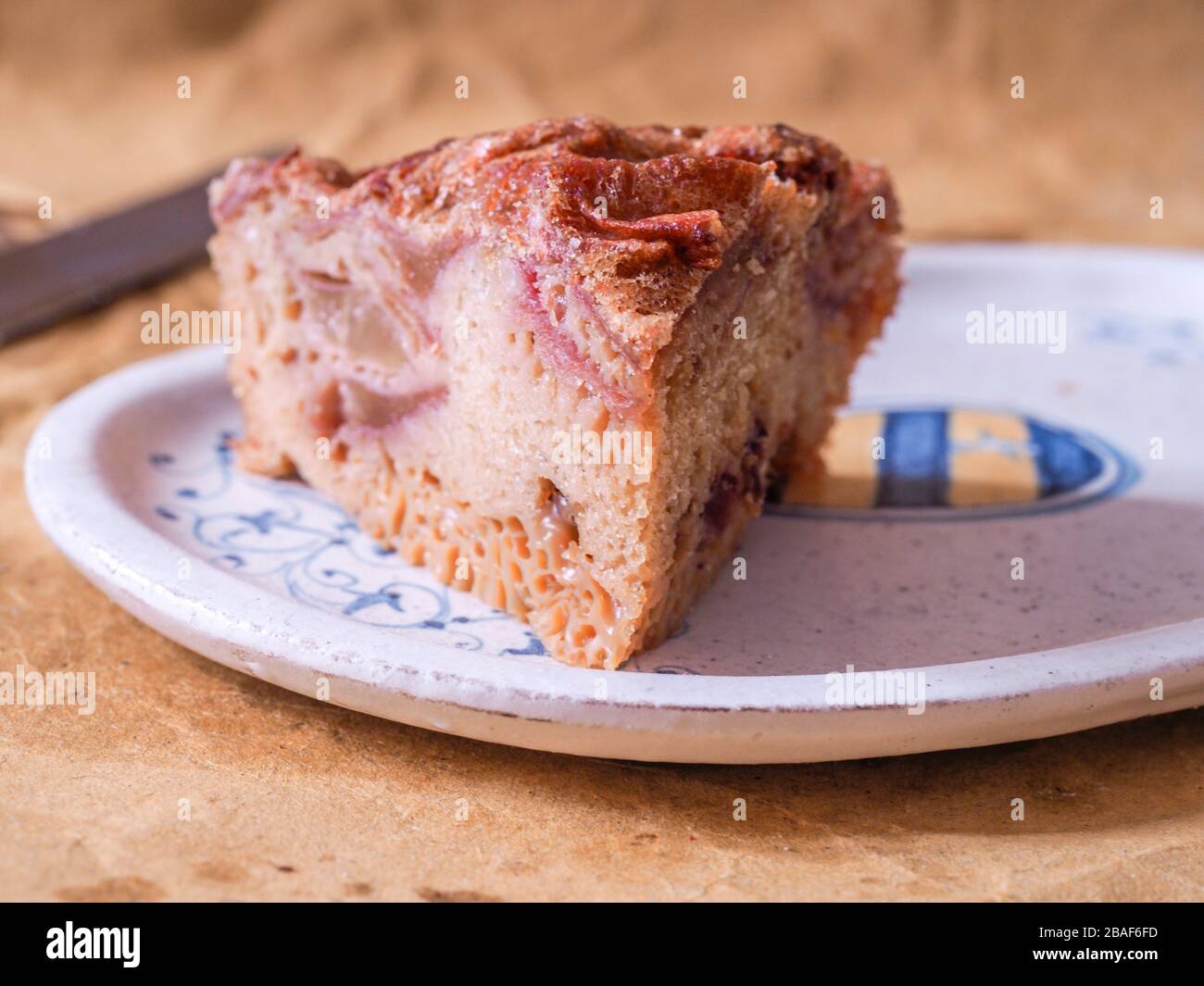 A photo of an whole flour apple pie in allu foil, on a dark rustic ...