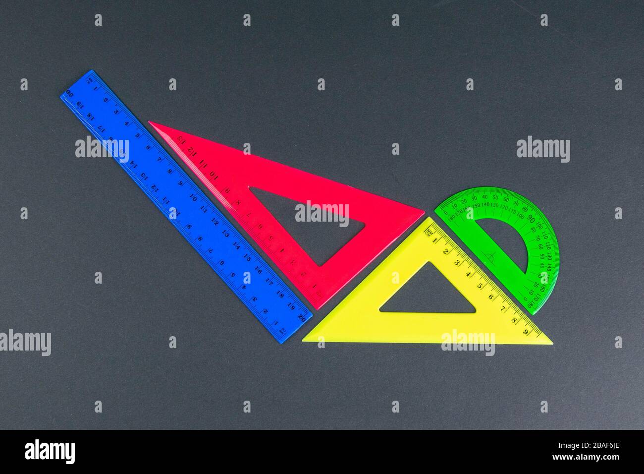 Back to school. Multicolored rulers on a black background. Copy space ...
