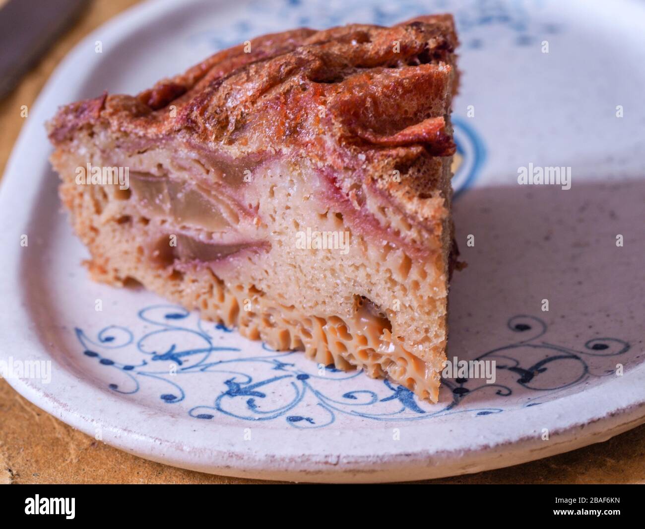 A photo of an whole flour apple pie in allu foil, on a dark rustic ...