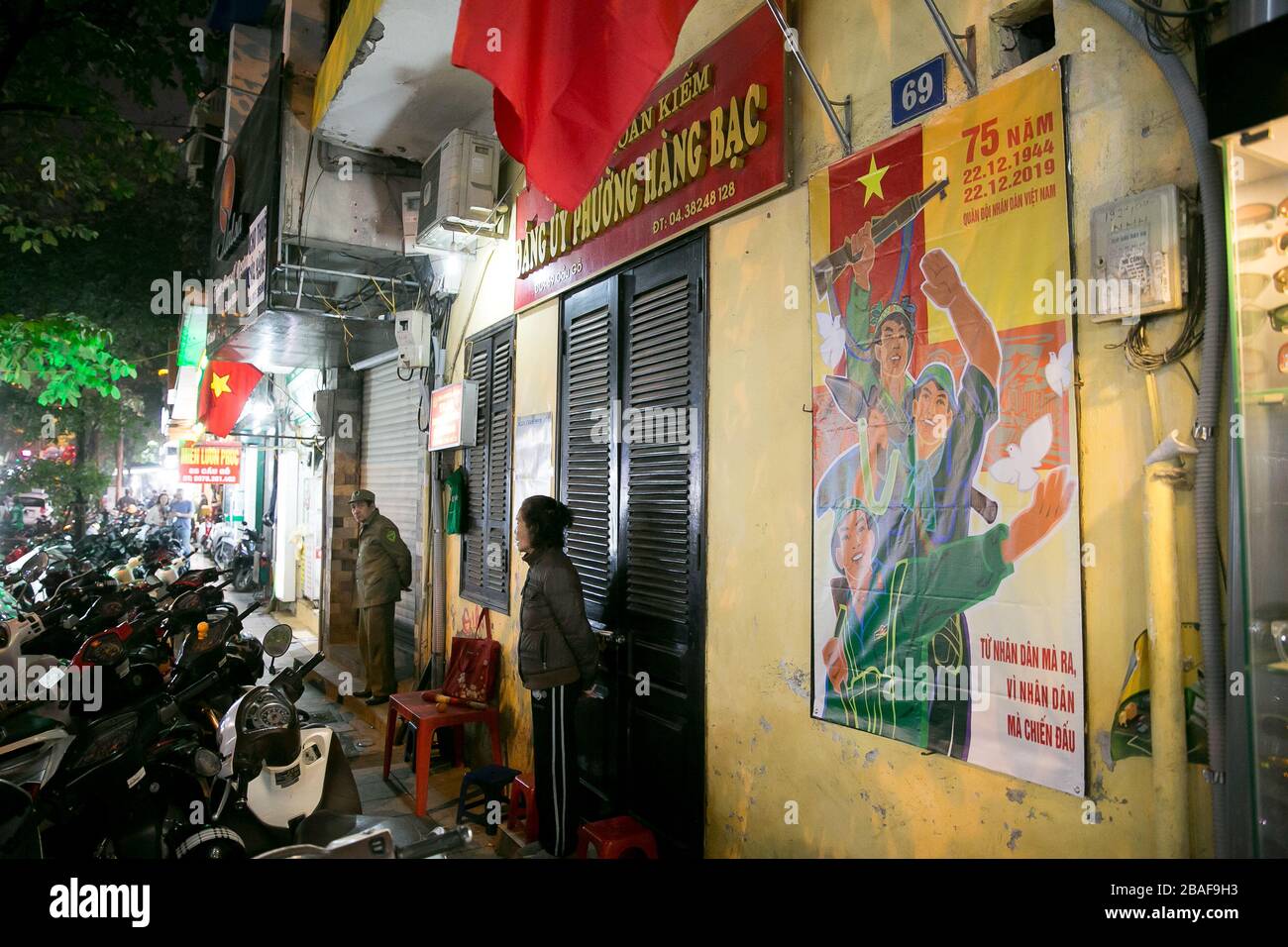 Local people stand outside buildings near a Vietnamese military ...