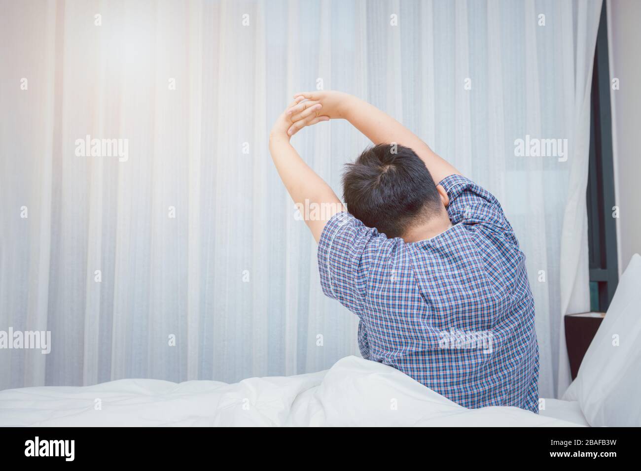 obese fat boy wakes up and stretching on bed in morning, Health care ...