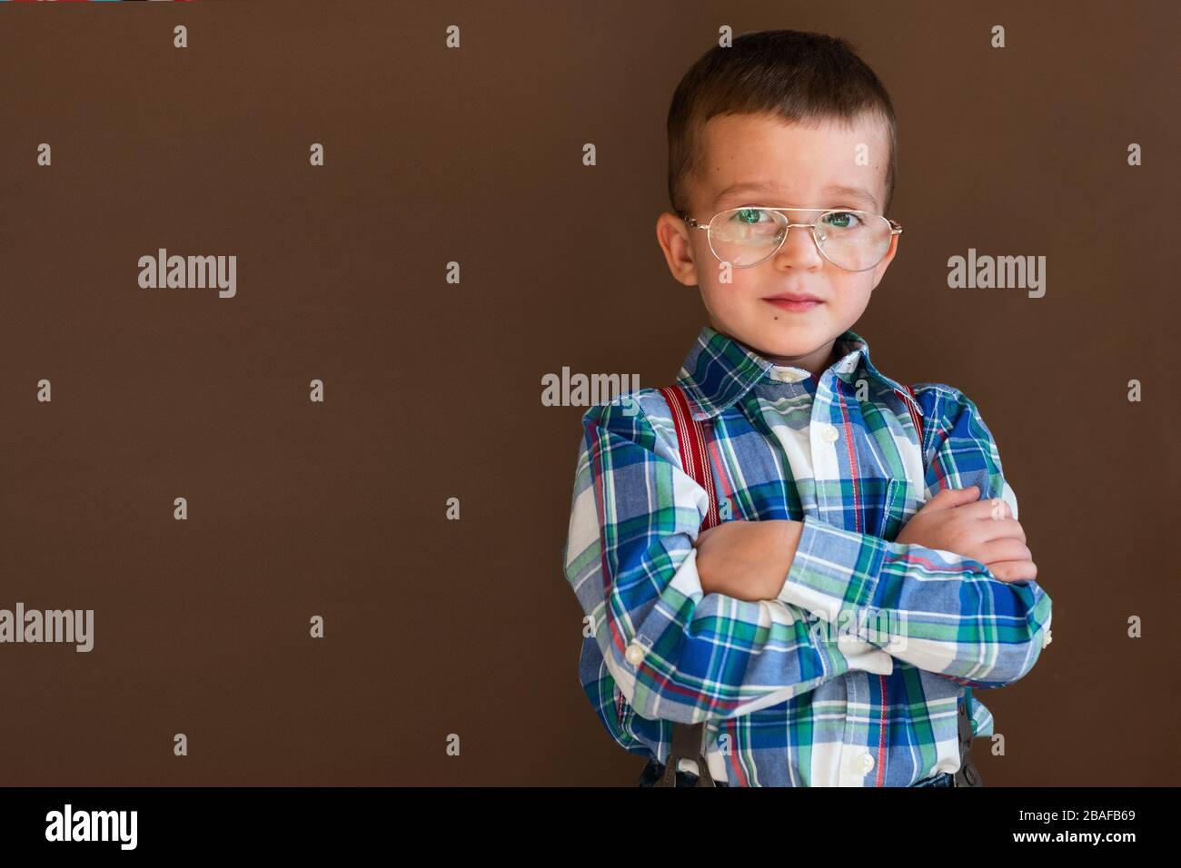Smiling kid looking at camera in front of blackboard Stock Photo - Alamy