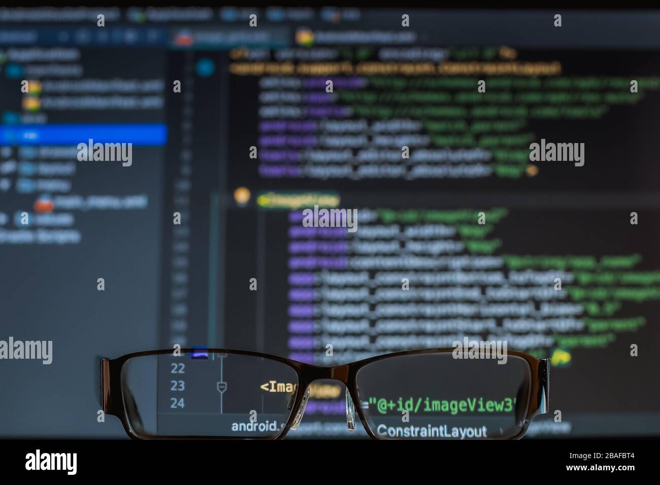 looking through glasses at developer screen with php code, notebook ...