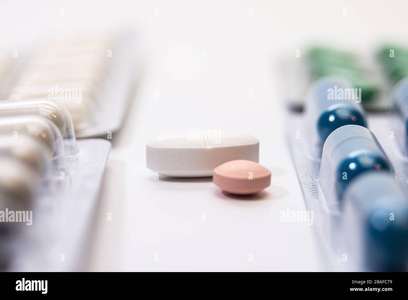 white packages and pills loose lying on a white isolated background ...