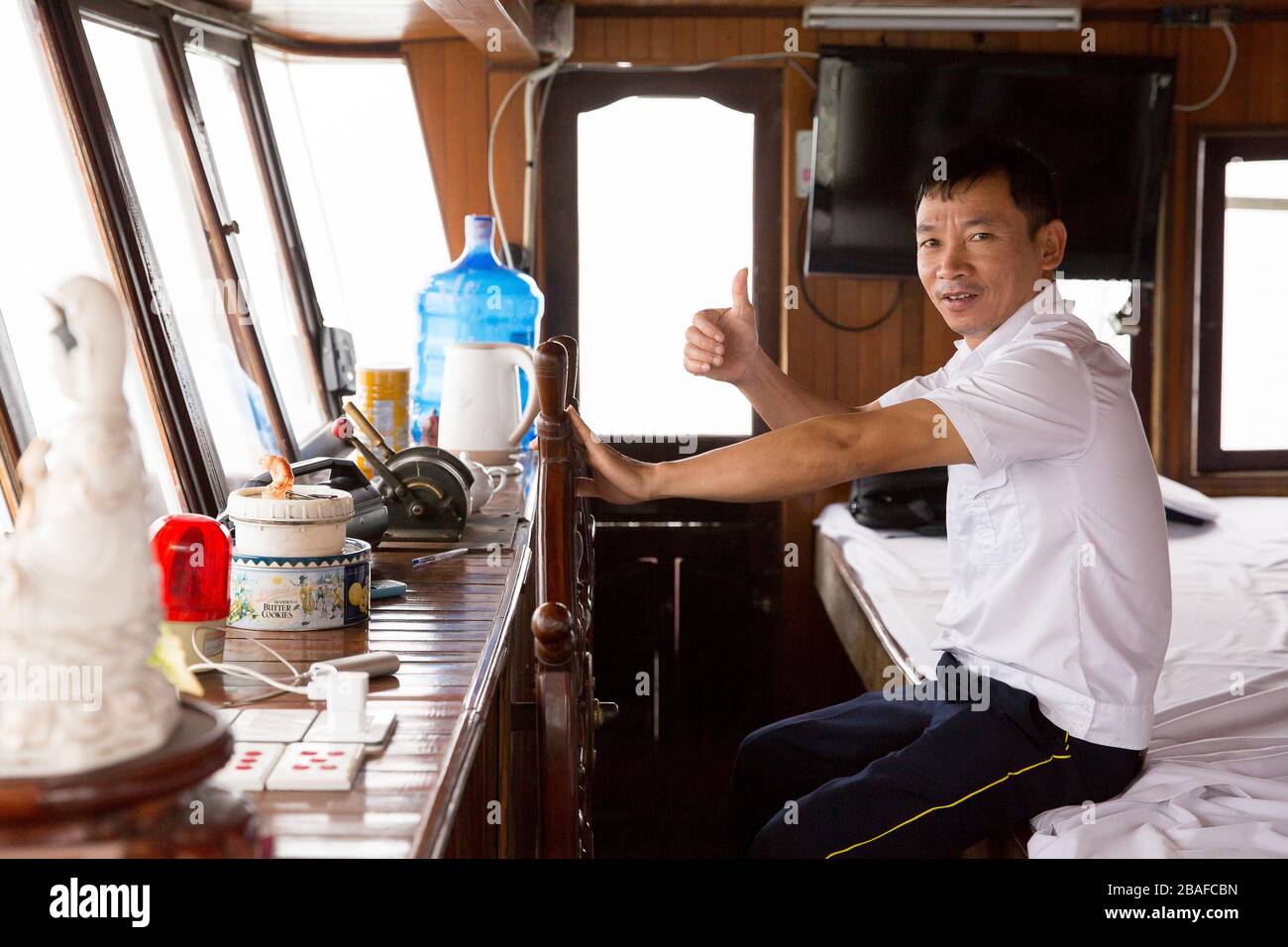 The Vietnamese captain gives a thumbs up while steering his boat Stock ...
