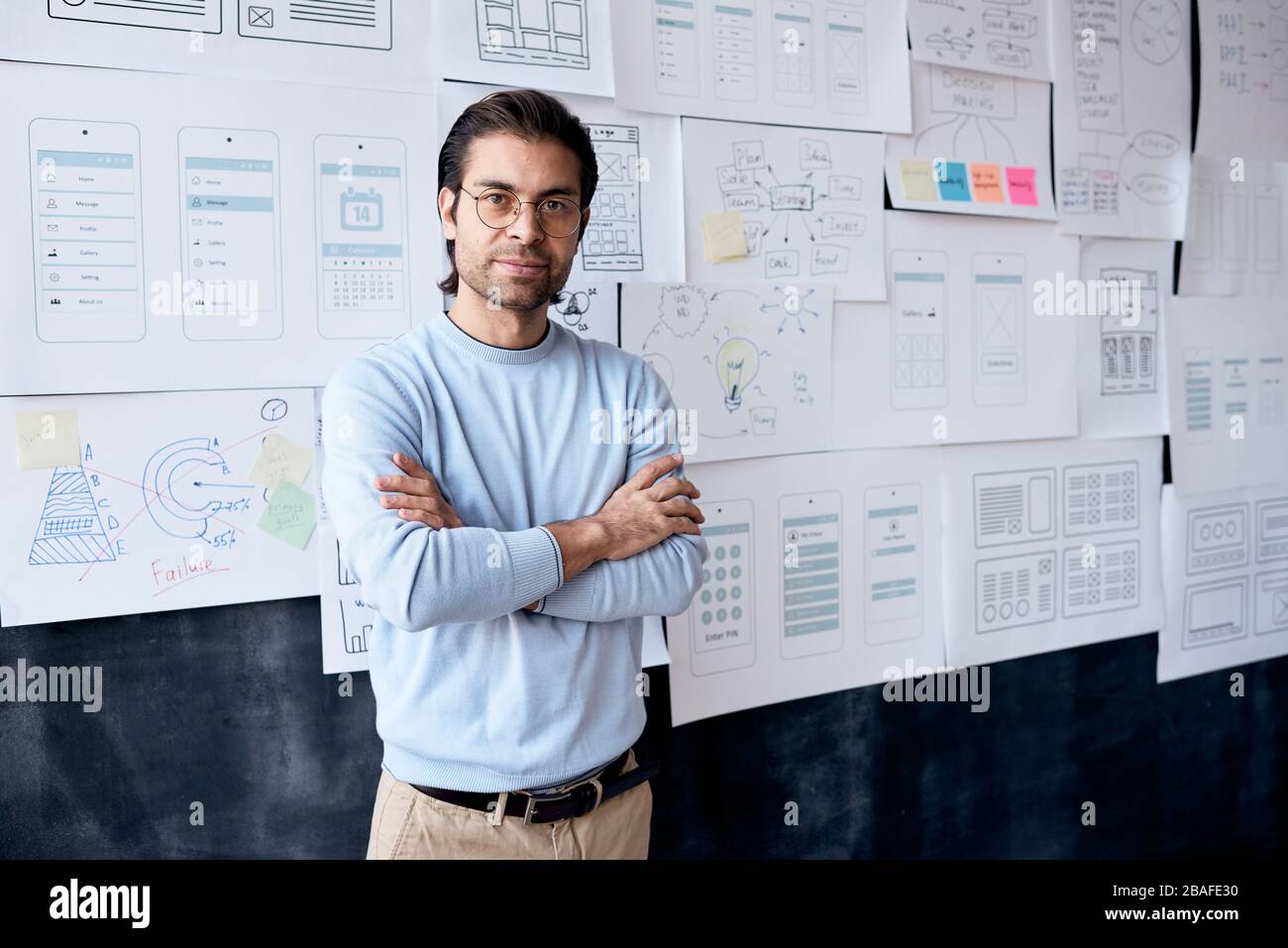 Portrait of content confident middle-aged man with stubble standing ...