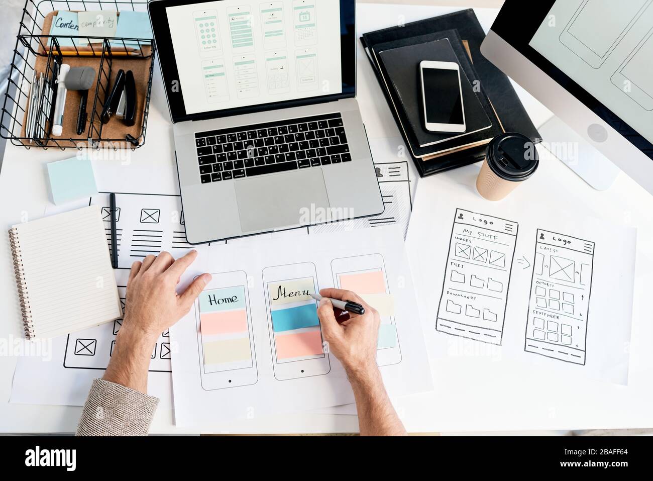 Above view of app interface designer making sticky notes on scheme ...