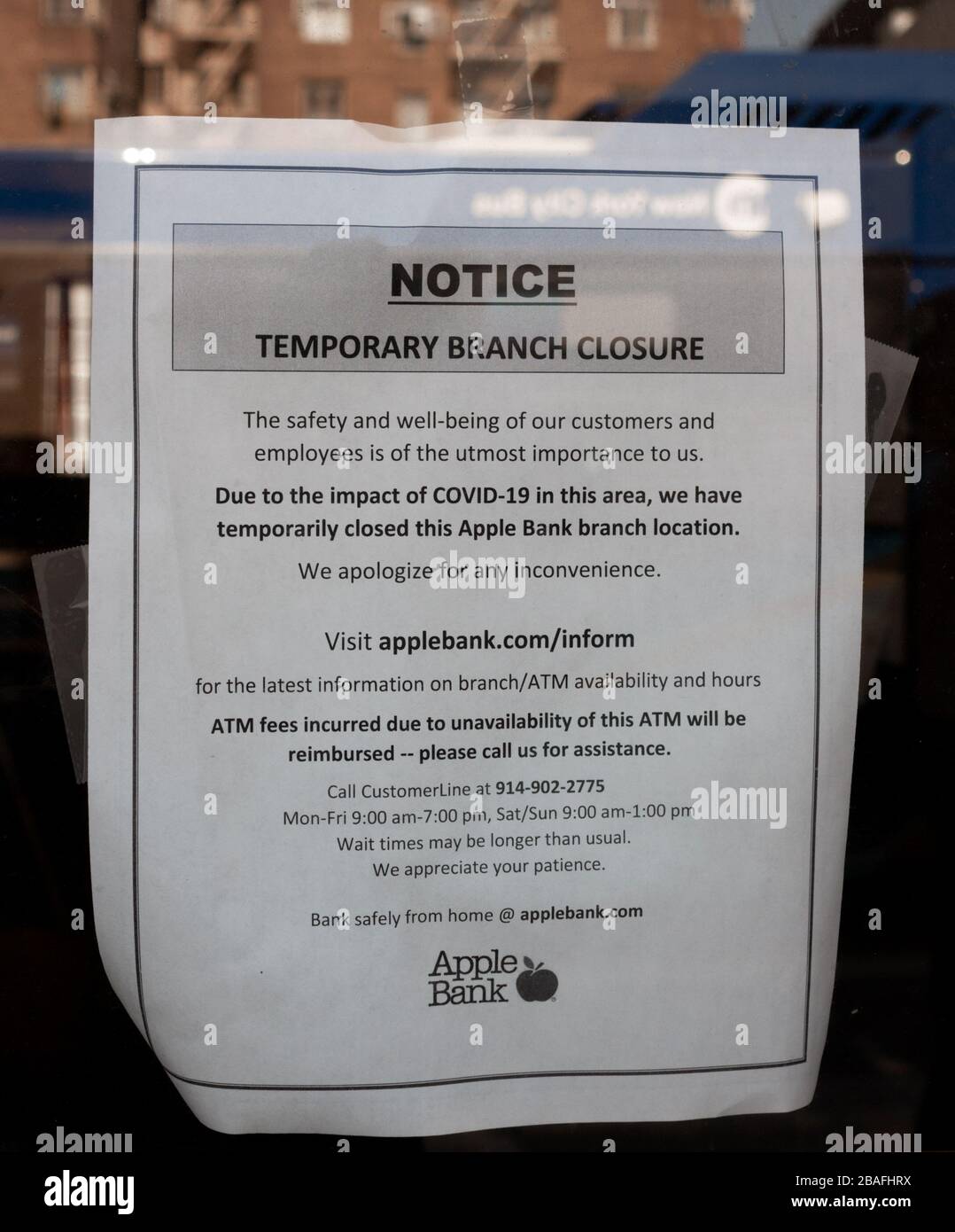 a sign in the door of the Inwood branch of Apple Bank states it is ...