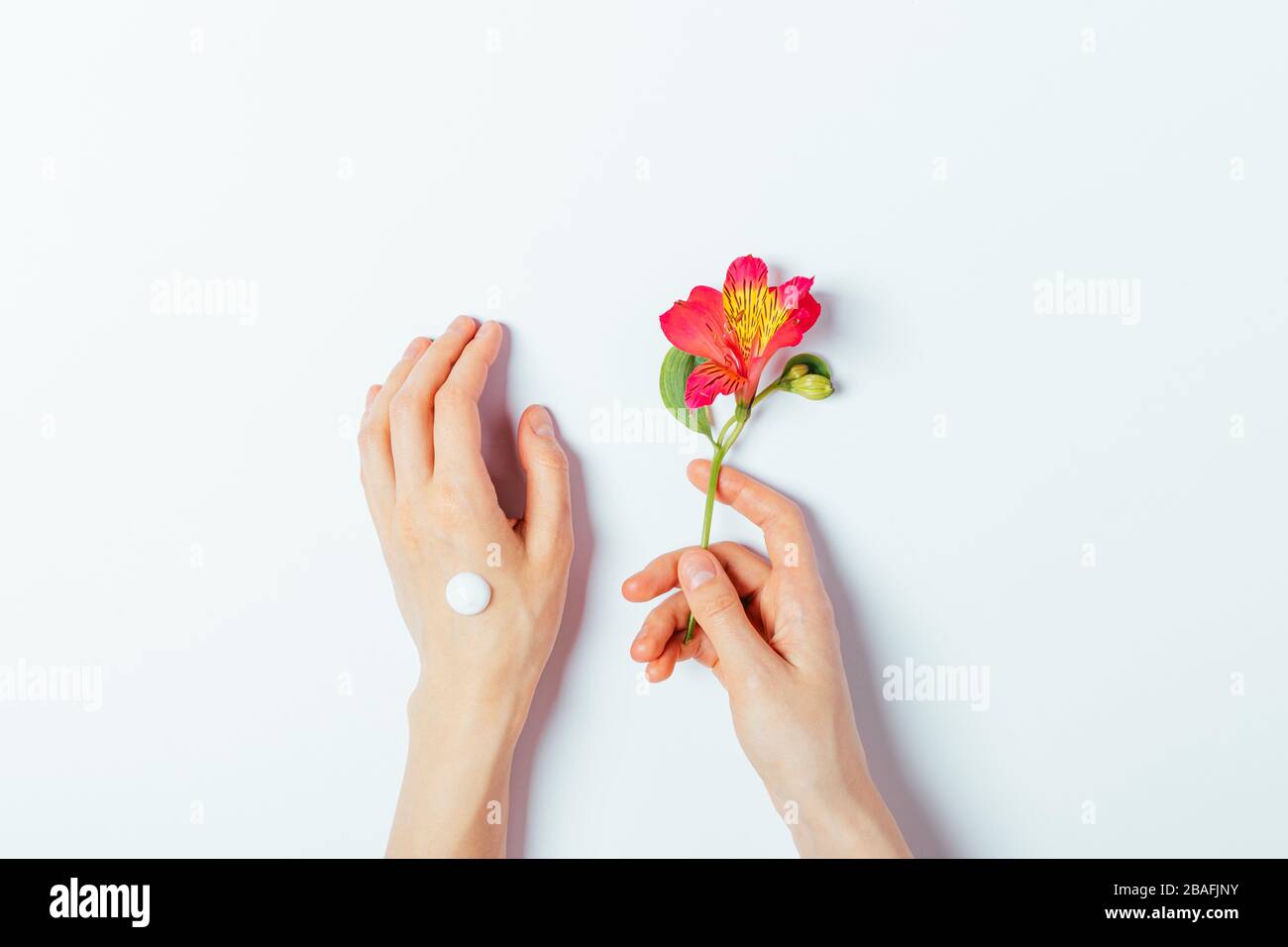 Woman's hand with drop of nourishing protective cream next to beautiful ...