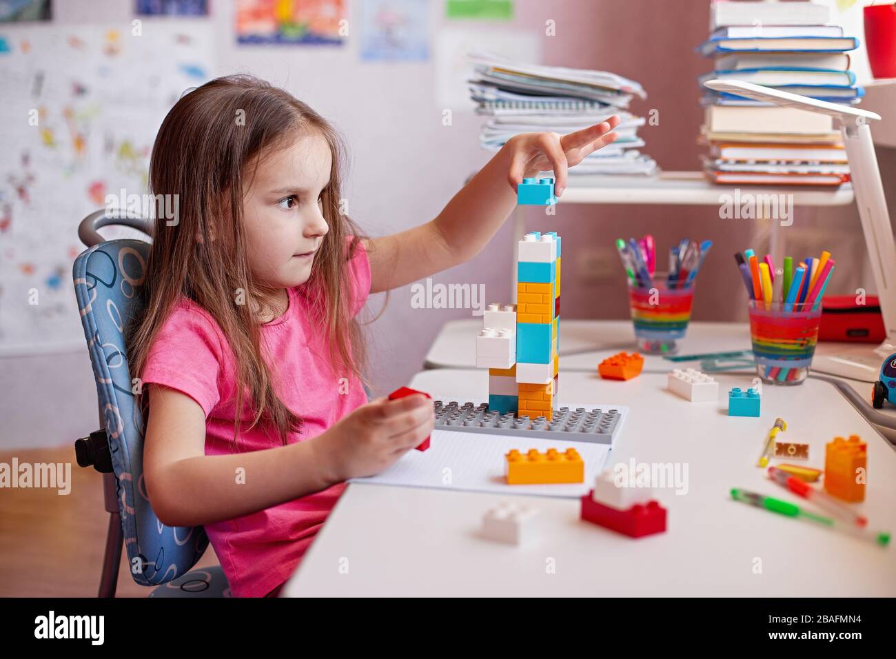 Child doing homework with textbooks and plays with his favorite toy at ...