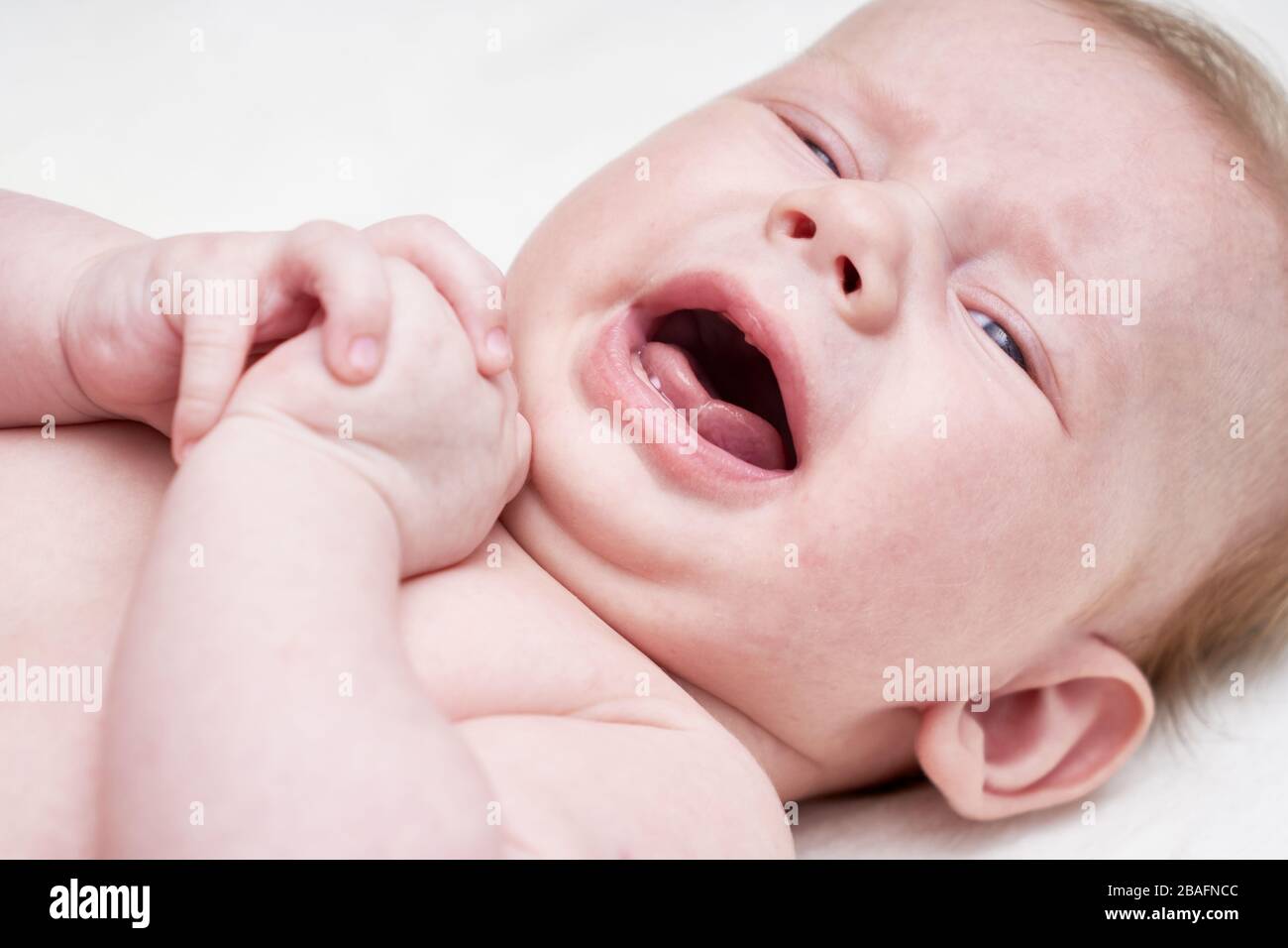 Cute crying baby on a light background Close up Stock Photo - Alamy