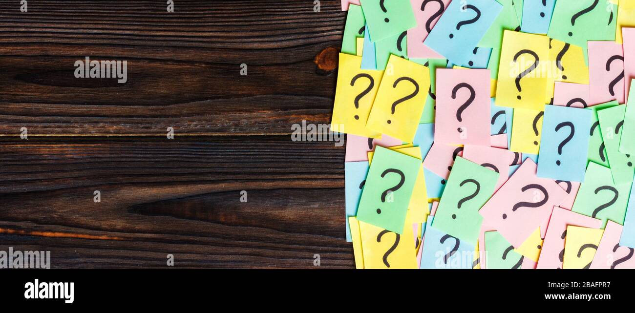 Too Many Questions on wooden background. Pile of colorful paper notes ...