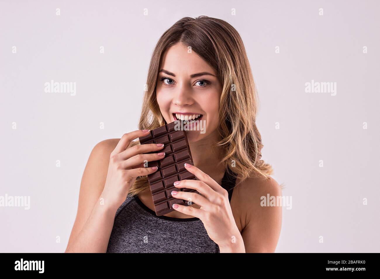 Tempted By Unhealthy Food Portrait Of Young Fitness Woman Eating