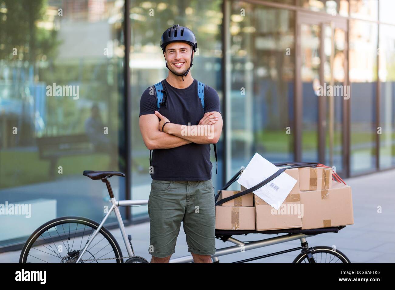 Bicycle messenger making a delivery on a cargo bike Stock Photo - Alamy
