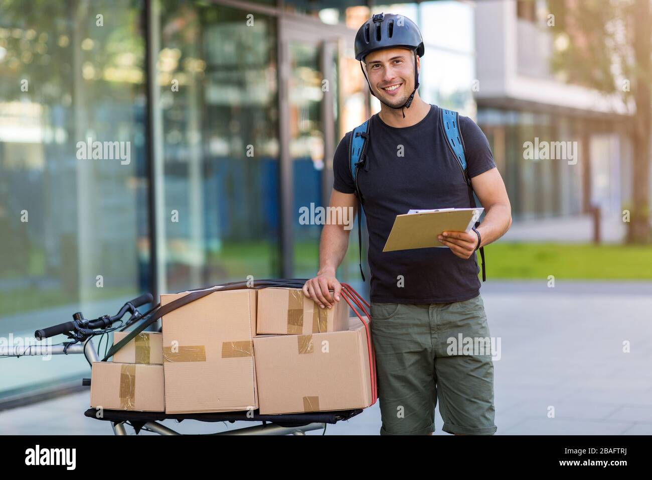 Bicycle messenger making a delivery on a cargo bike Stock Photo - Alamy