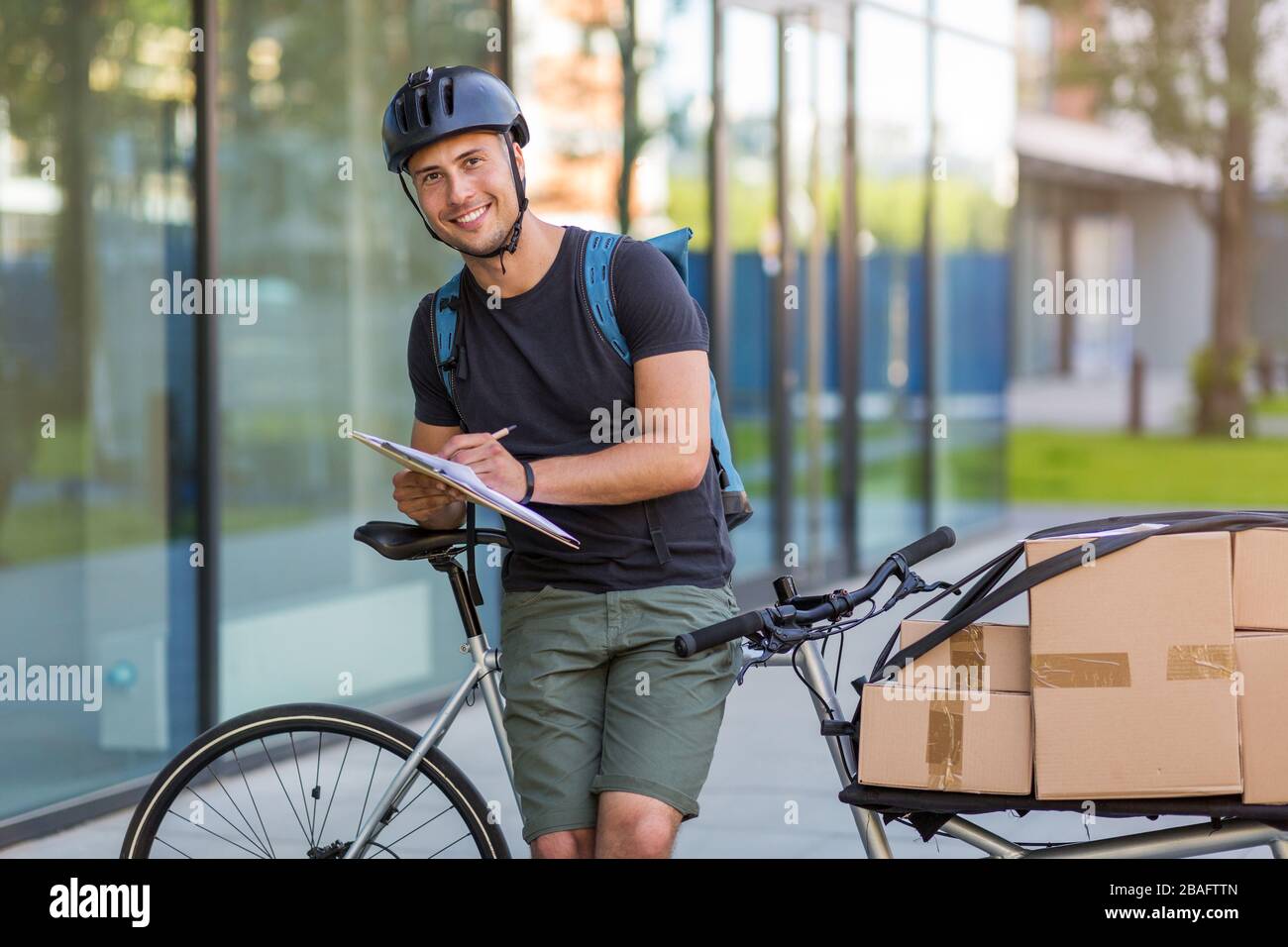 Bicycle messenger making a delivery on a cargo bike Stock Photo - Alamy