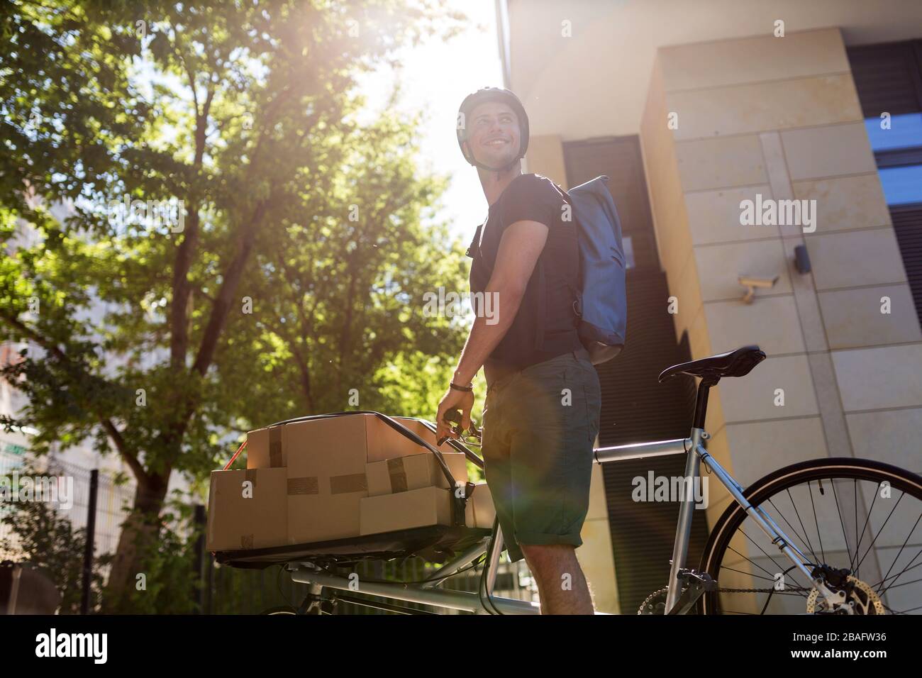 Bicycle messenger making a delivery on a cargo bike Stock Photo - Alamy