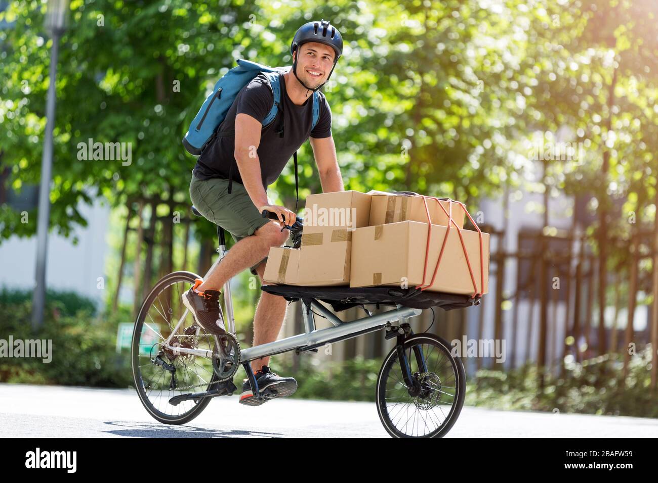 Bicycle messenger making a delivery on a cargo bike Stock Photo - Alamy