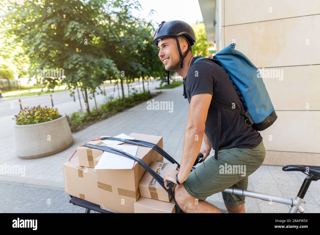 Bicycle messenger making a delivery on a cargo bike Stock Photo - Alamy