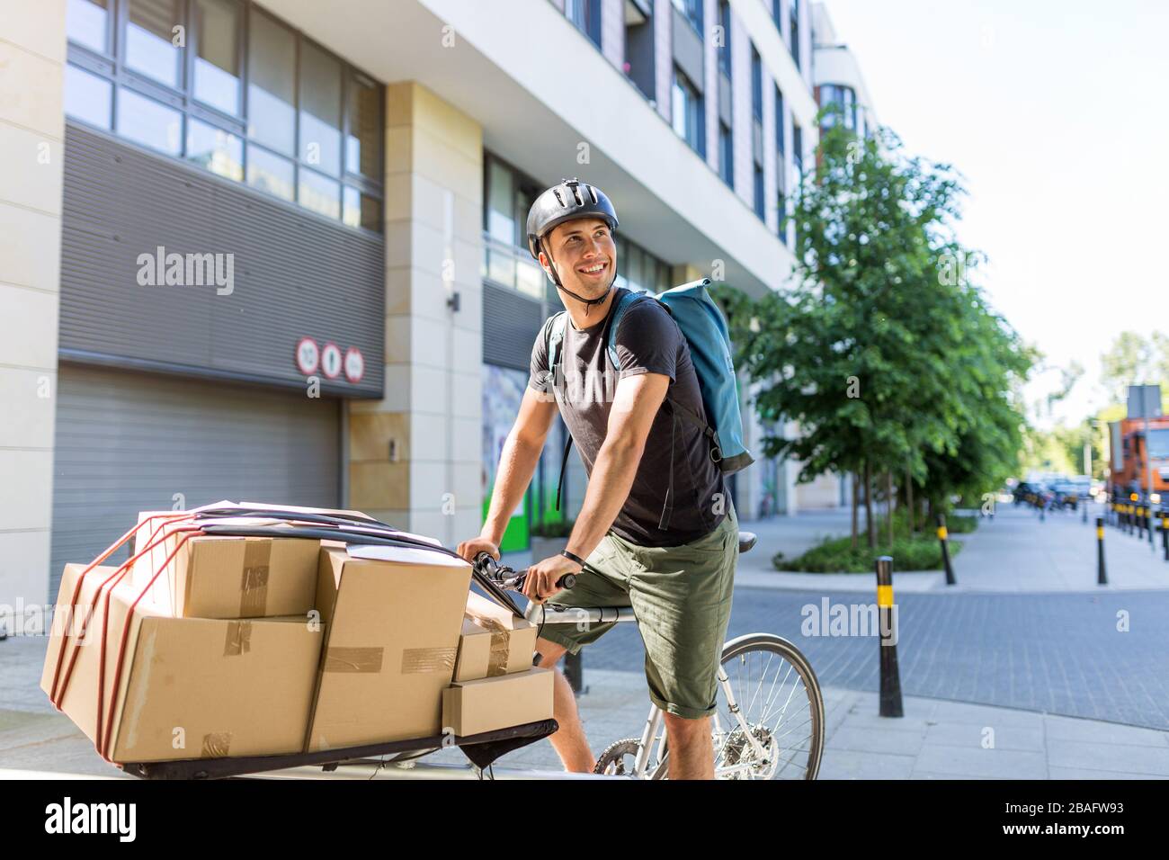 Bicycle messenger making a delivery on a cargo bike Stock Photo - Alamy
