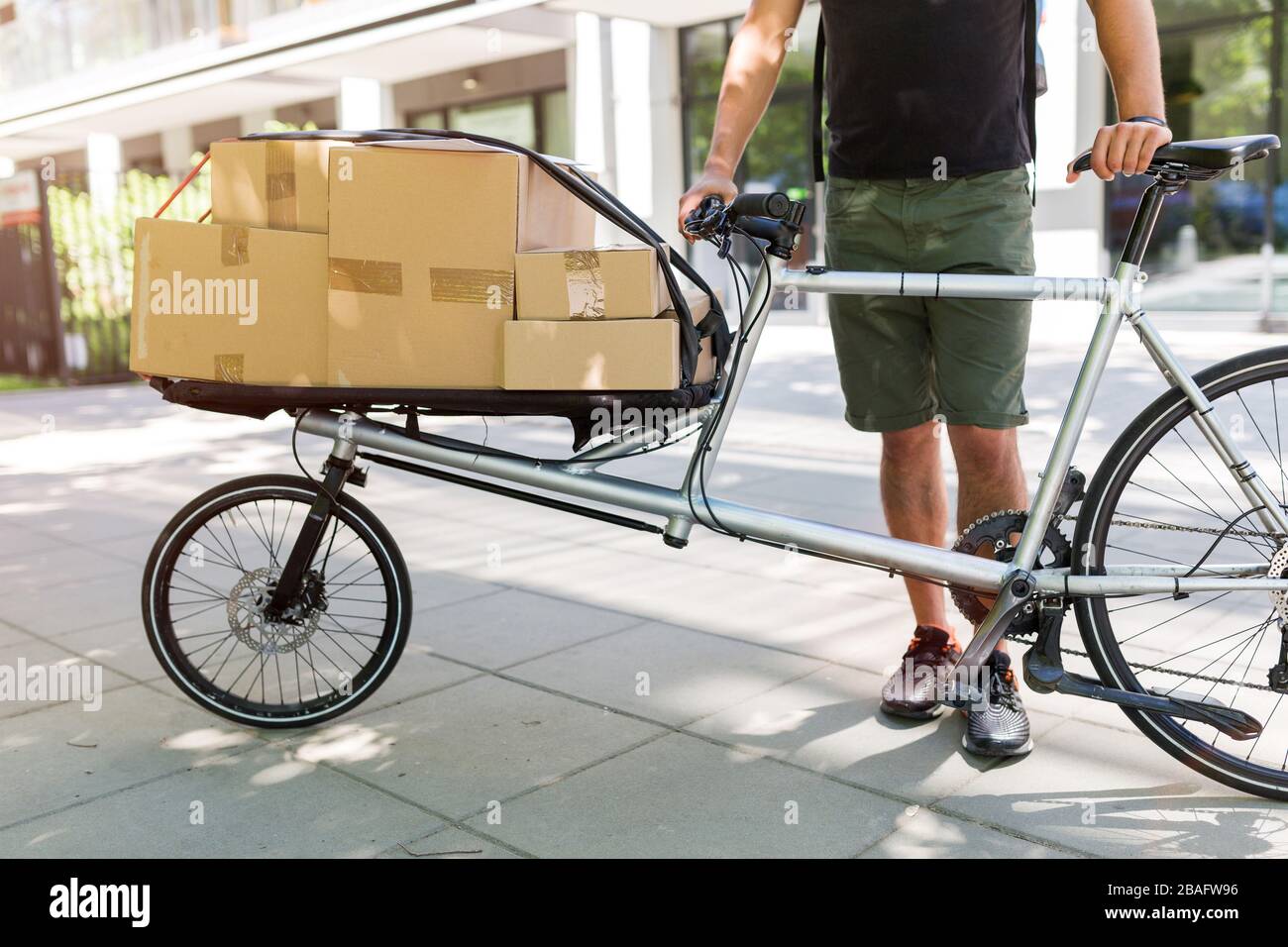 Bicycle messenger making a delivery on a cargo bike Stock Photo - Alamy