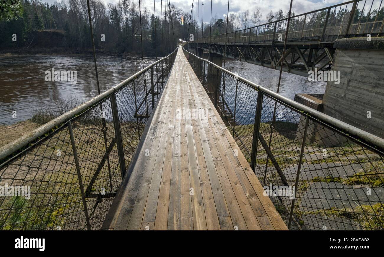 beautiful spring landscape with a cable bridge over the river. River ...
