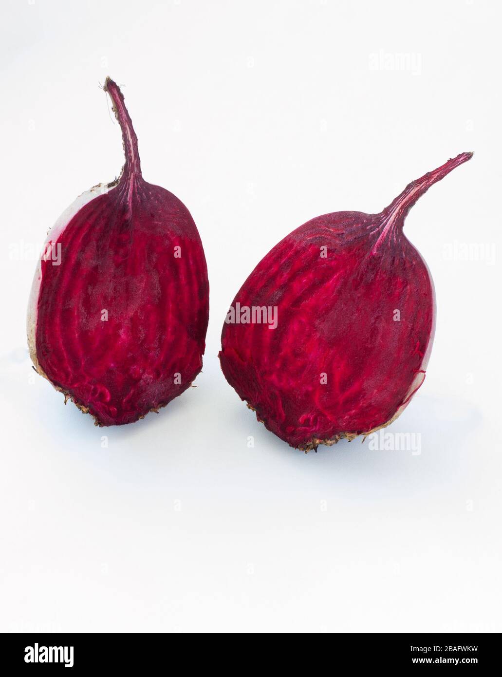 Cut into two parts red beet on white background Stock Photo - Alamy