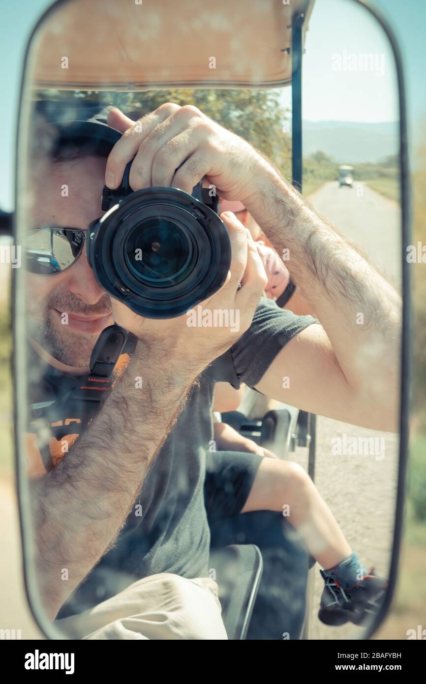 Israeli man reflected on the side mirror of an electric golf cart while ...
